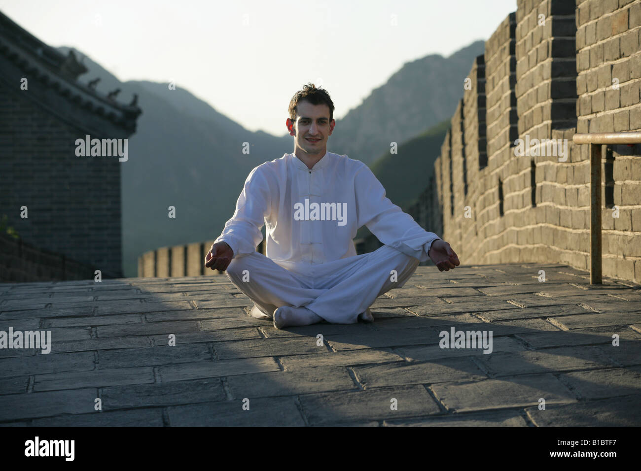 caucasian in Chinese traditional clothing sitting in lotus position on ...