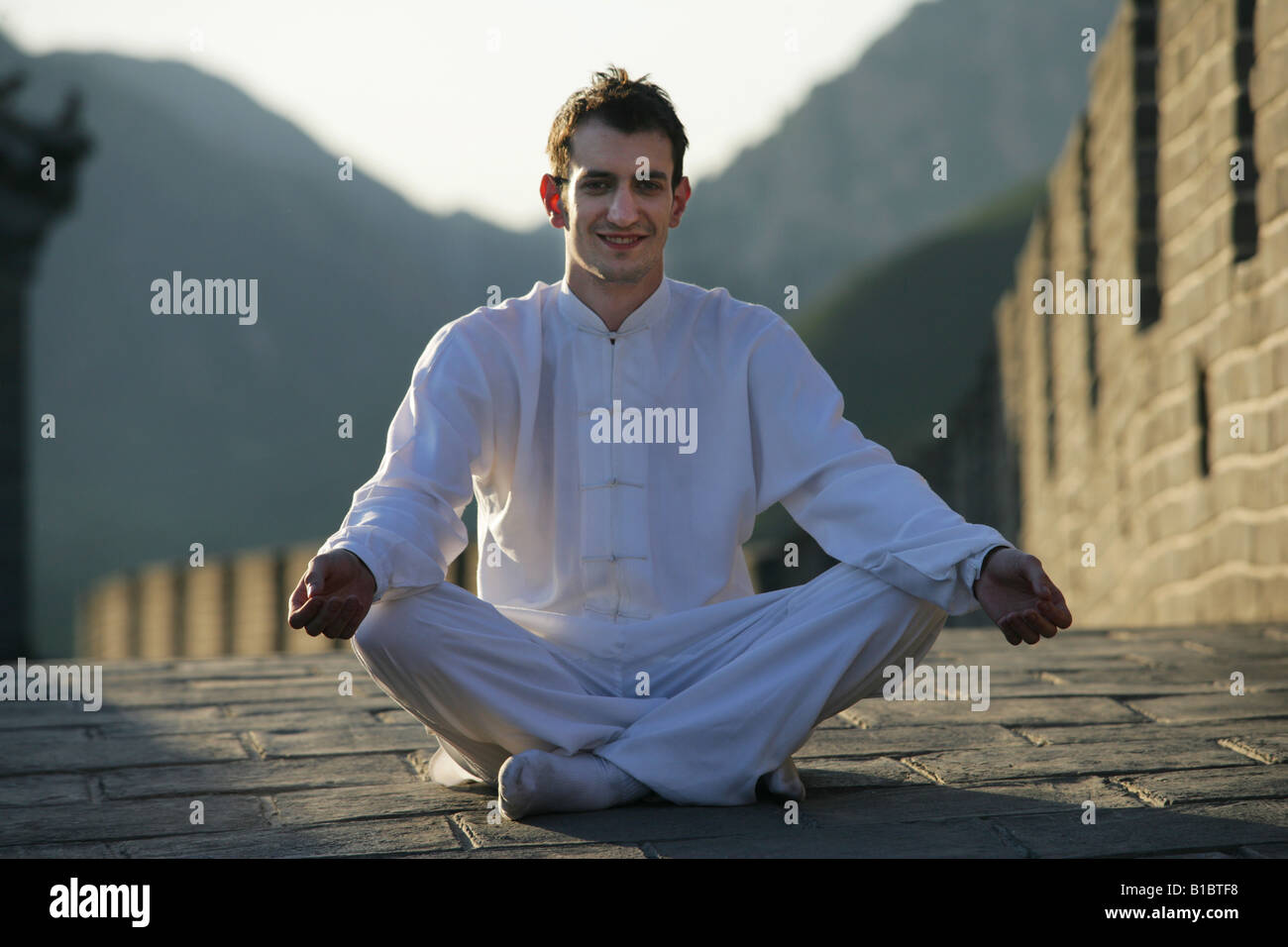 caucasian in Chinese traditional clothing sitting in lotus position on ...