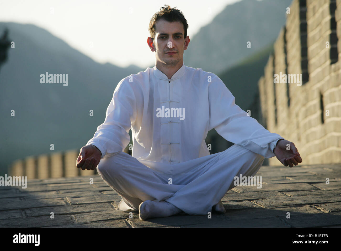caucasian in Chinese traditional clothing sitting in lotus position on ...