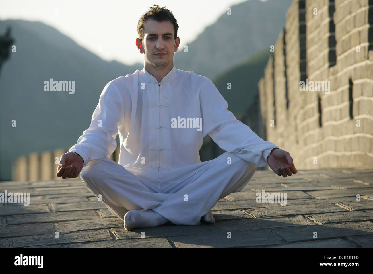 caucasian in Chinese traditional clothing sitting in lotus position on ...