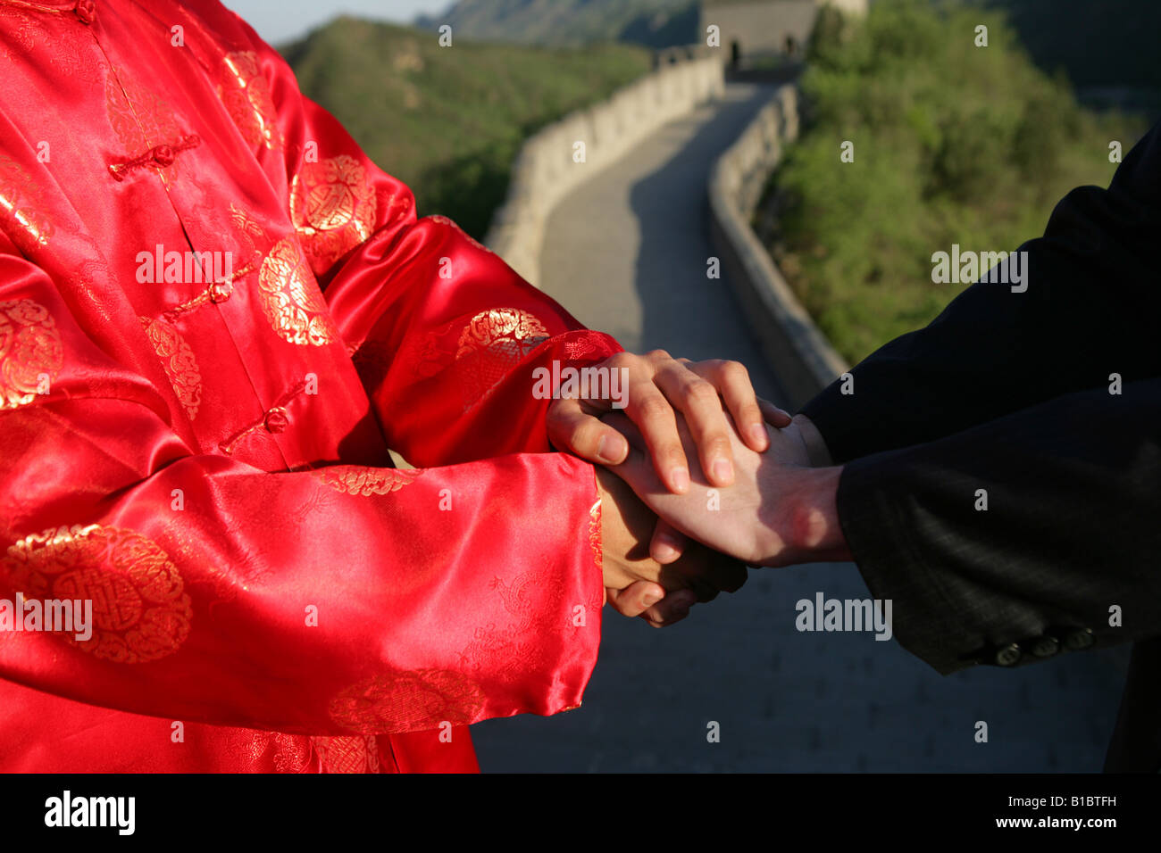 Chinese traditional man and caucasian businessman handshaking on Great ...