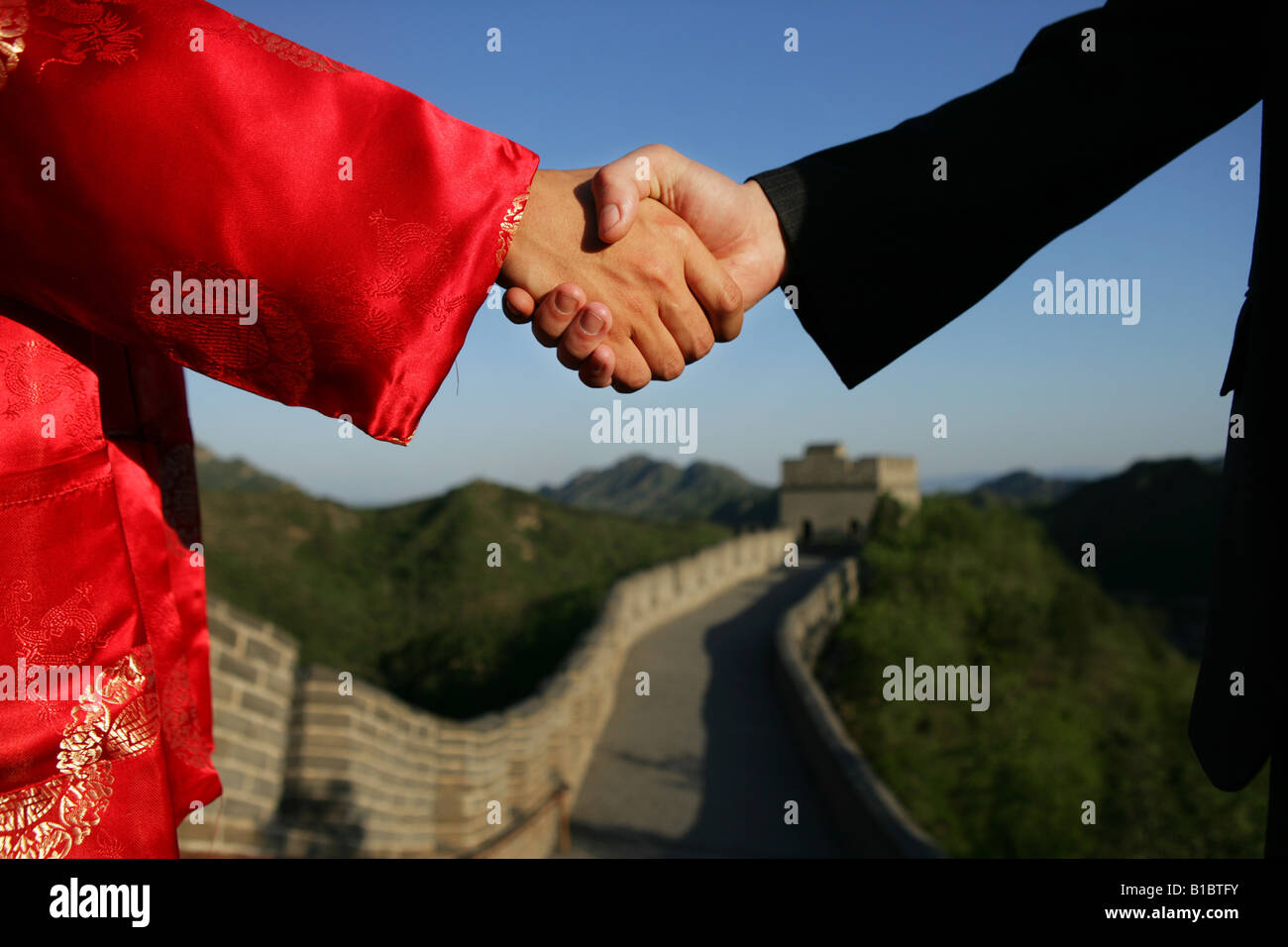 Chinese traditional man and caucasian businessman handshaking on Great ...
