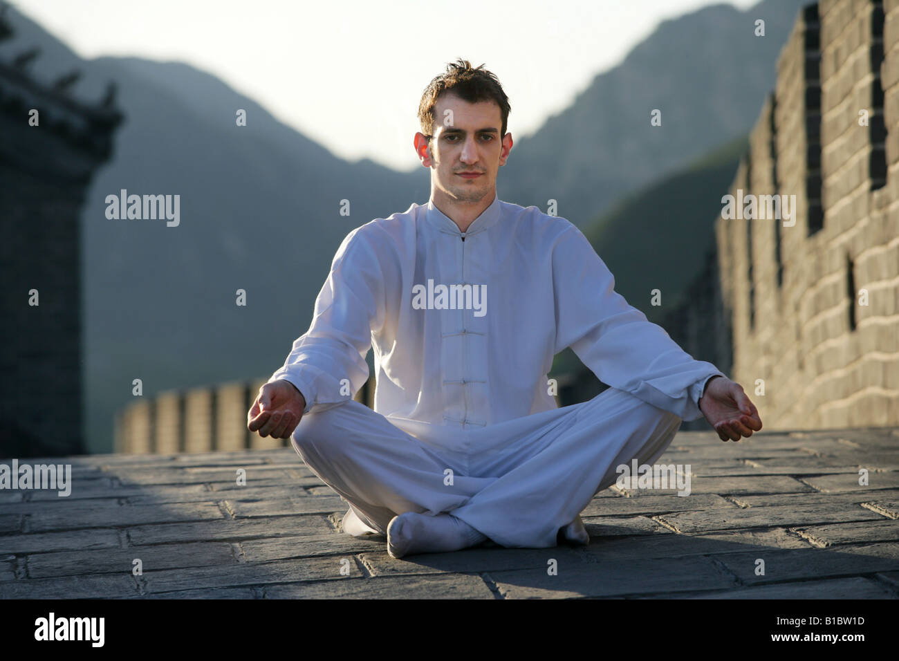 caucasian in Chinese traditional clothing sitting in lotus position on ...