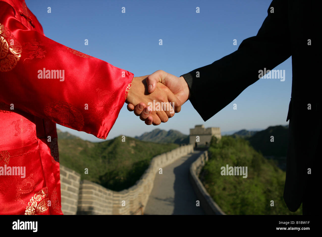 Chinese traditional man and caucasian businessman handshaking on Great ...