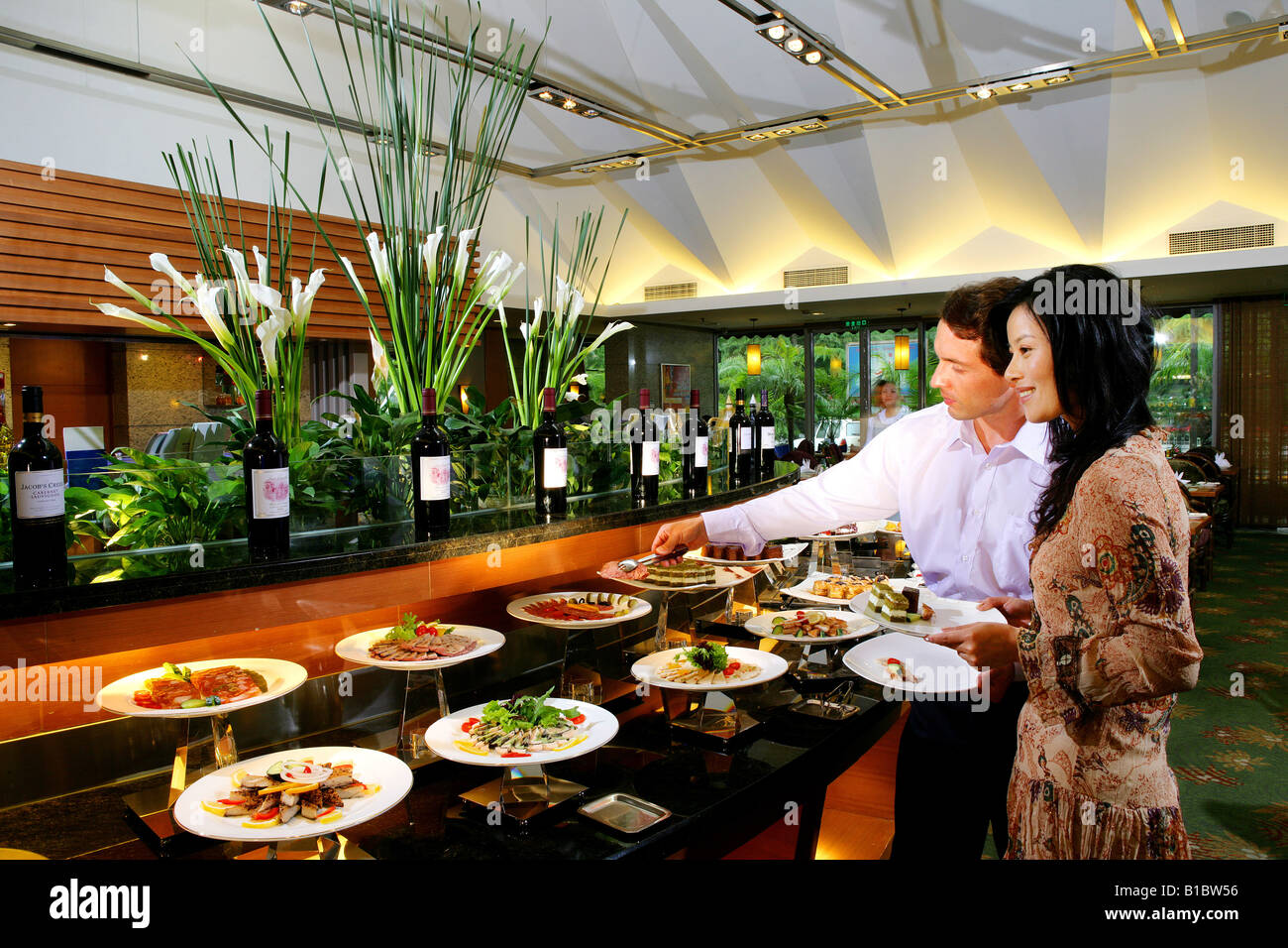 two guests from different cultures taking food in hotel restaurant ...