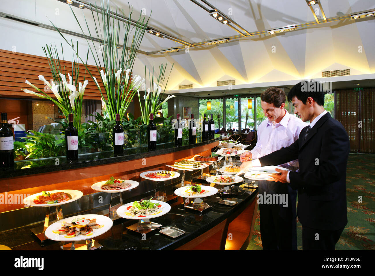 two guests from different cultures taking food in hotel restaurant ...