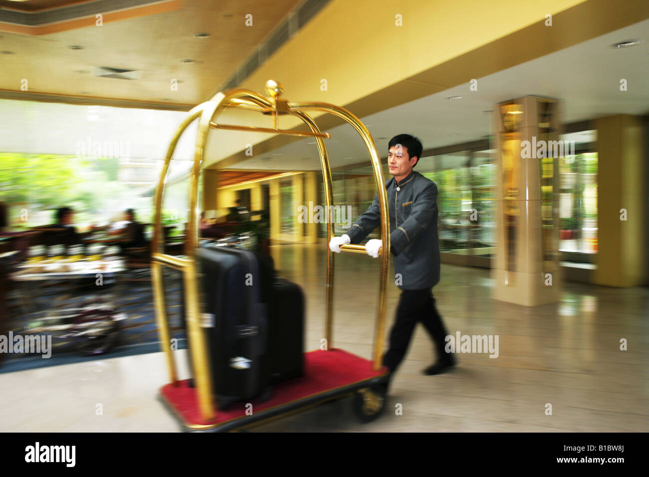 bellhop pushing luggage cart Stock Photo - Alamy