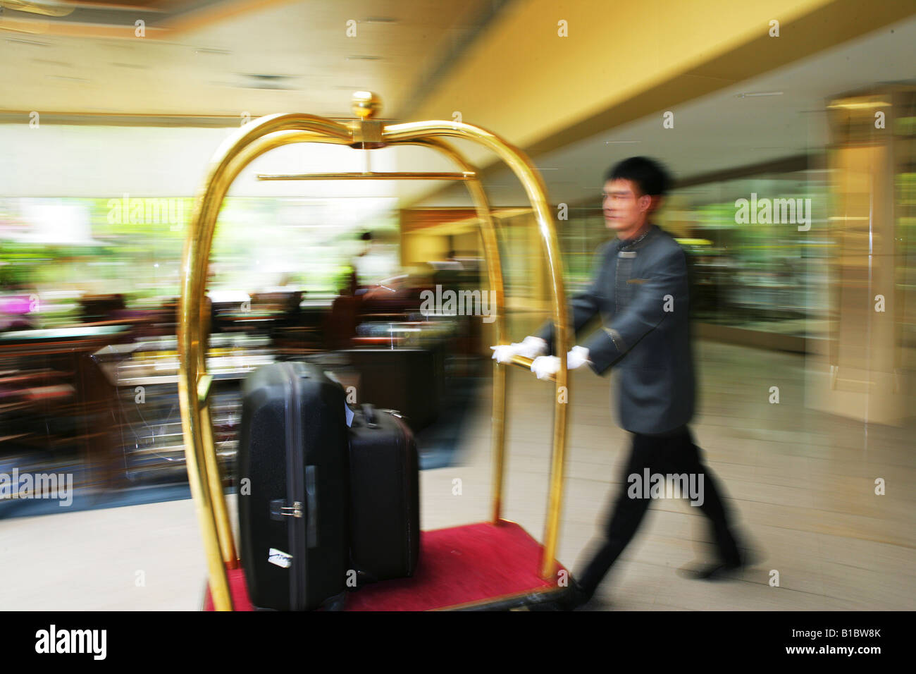 bellhop pushing luggage cart Stock Photo - Alamy