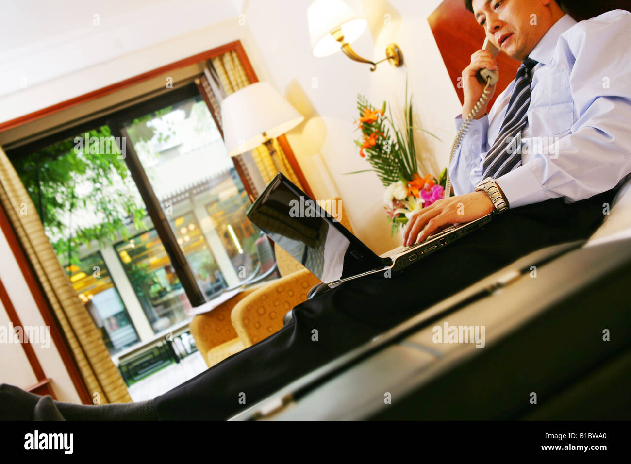 businessman using mobile phone and laptop in hotel room Stock Photo - Alamy
