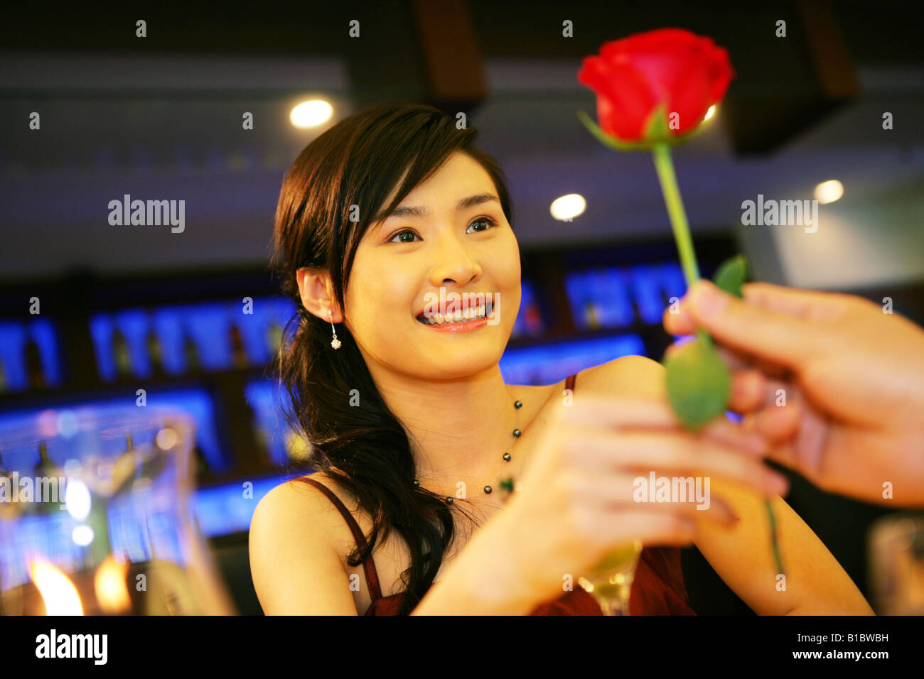 young woman receiving rose in bar of hotel Stock Photo - Alamy