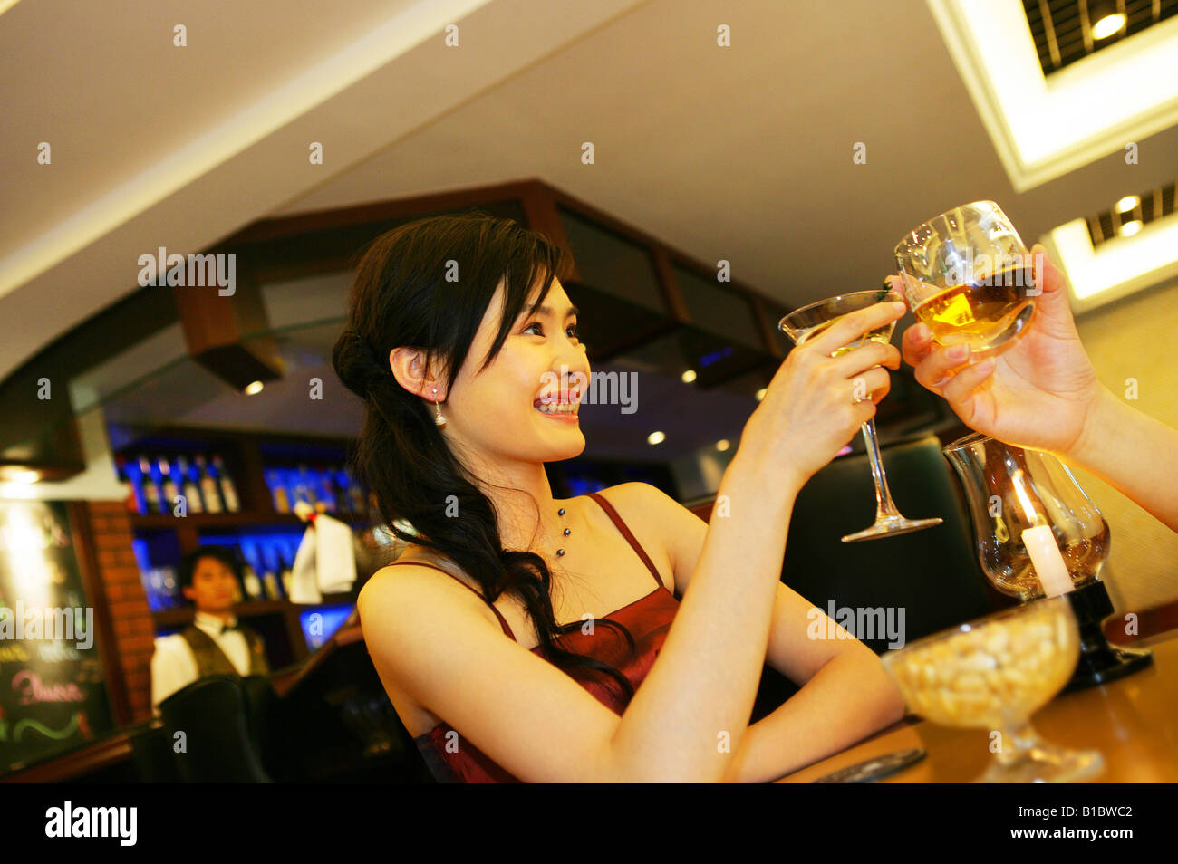 young woman toasting in bar of hotel Stock Photo - Alamy