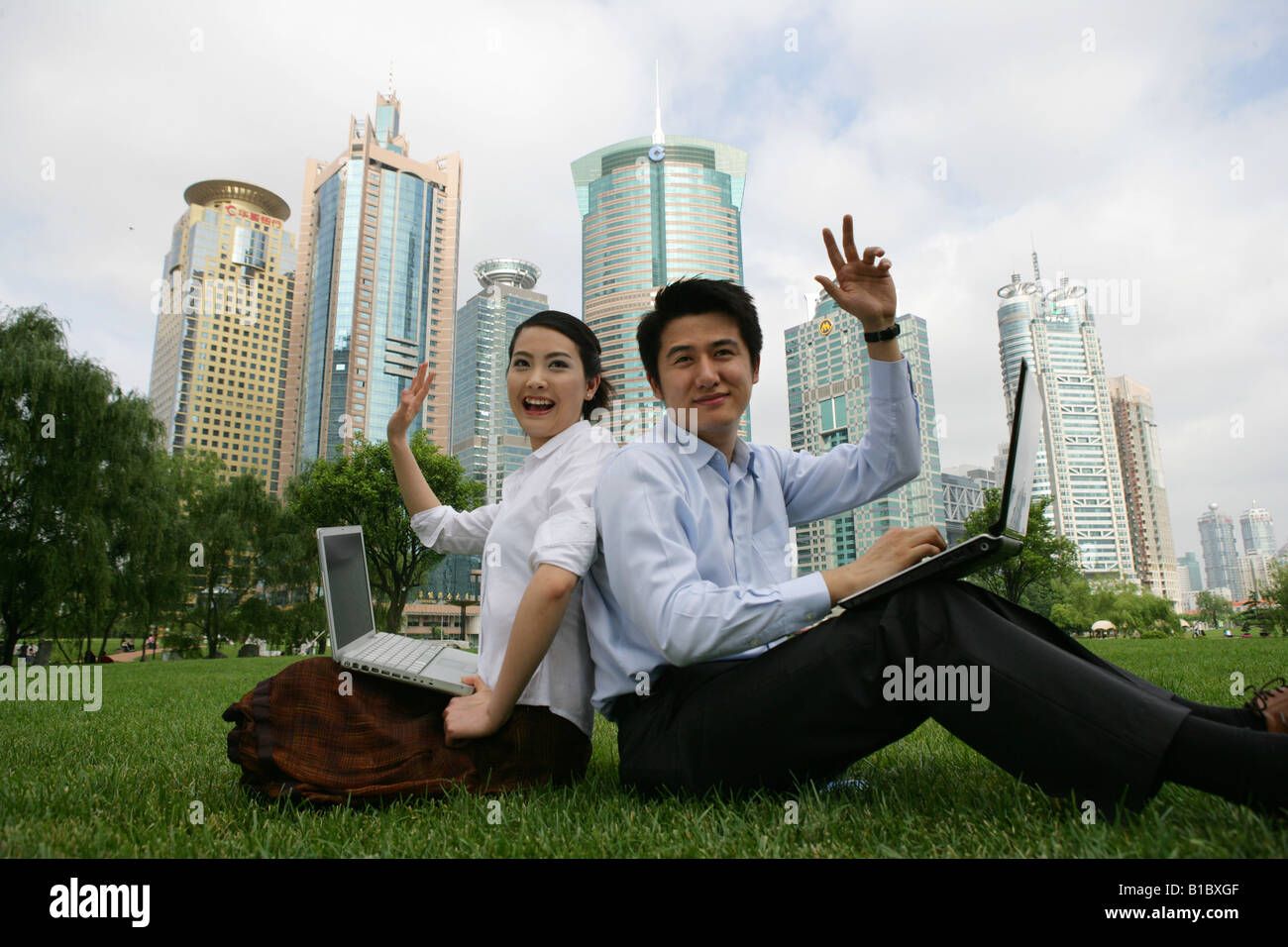 one businessman and one businesswoman gesturing V signs outside office ...