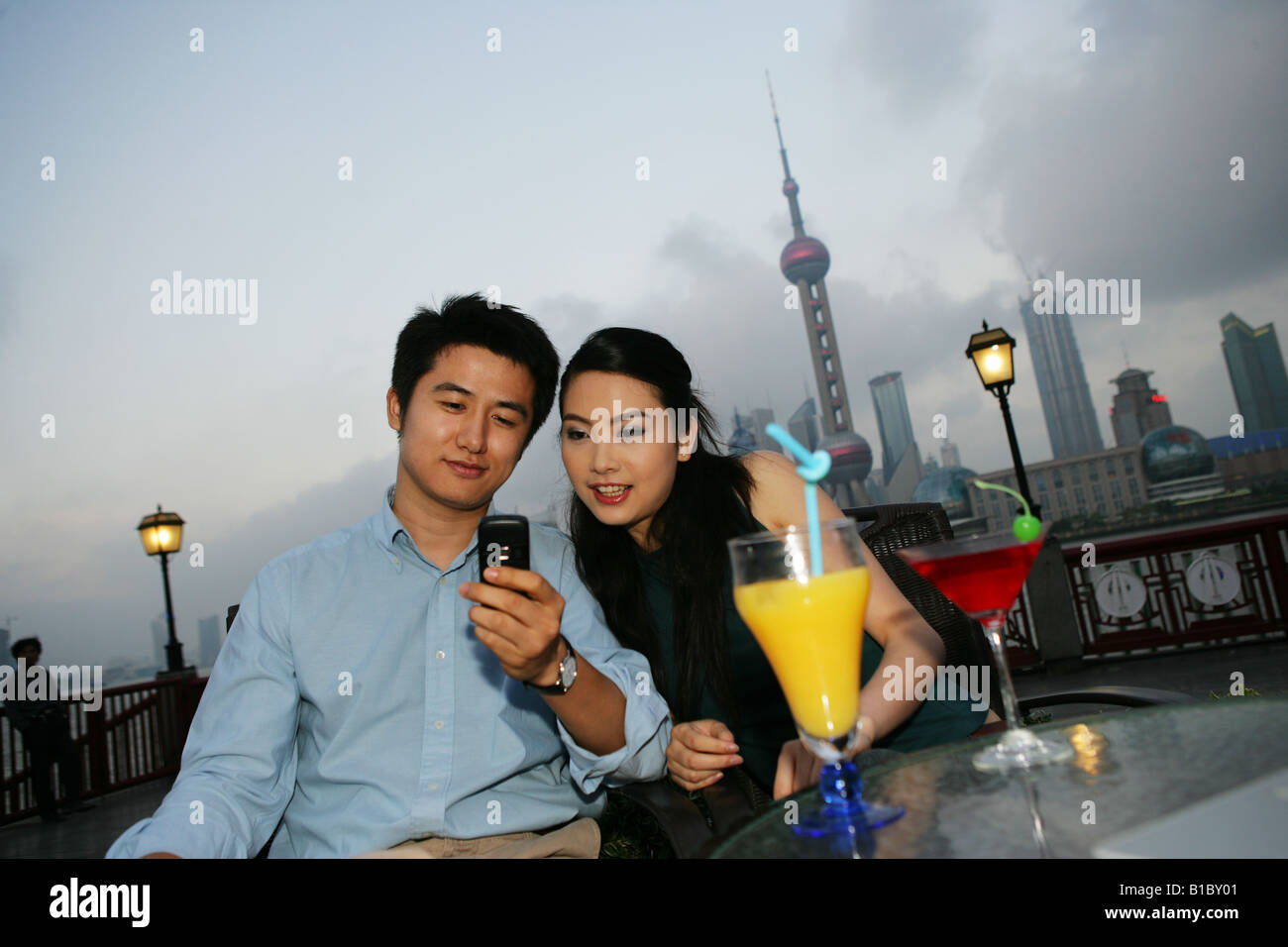 couple using mobile phone beside table on the Bund,Shanghai,China Stock ...