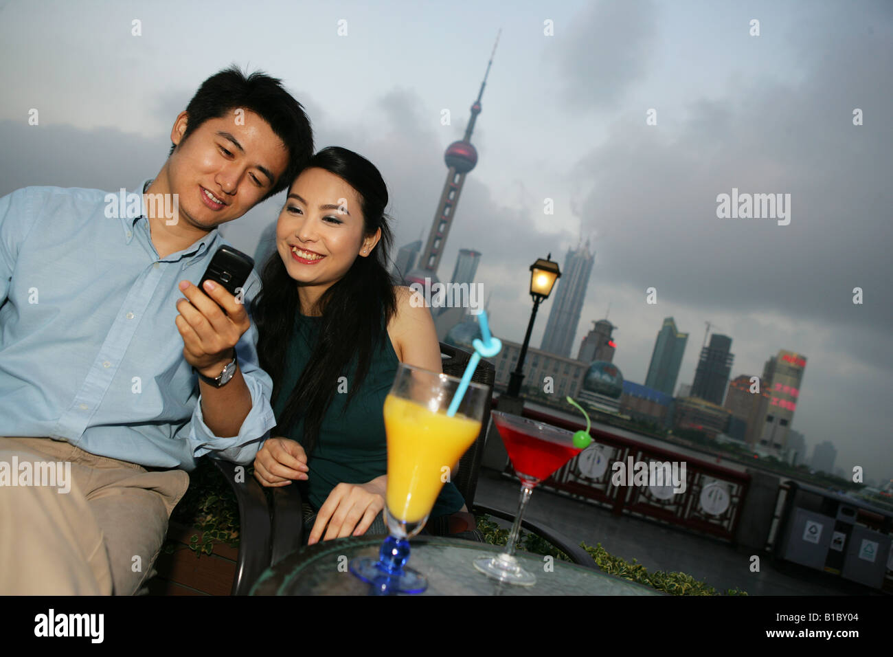 couple using mobile phone beside table on the Bund,Shanghai,China Stock ...