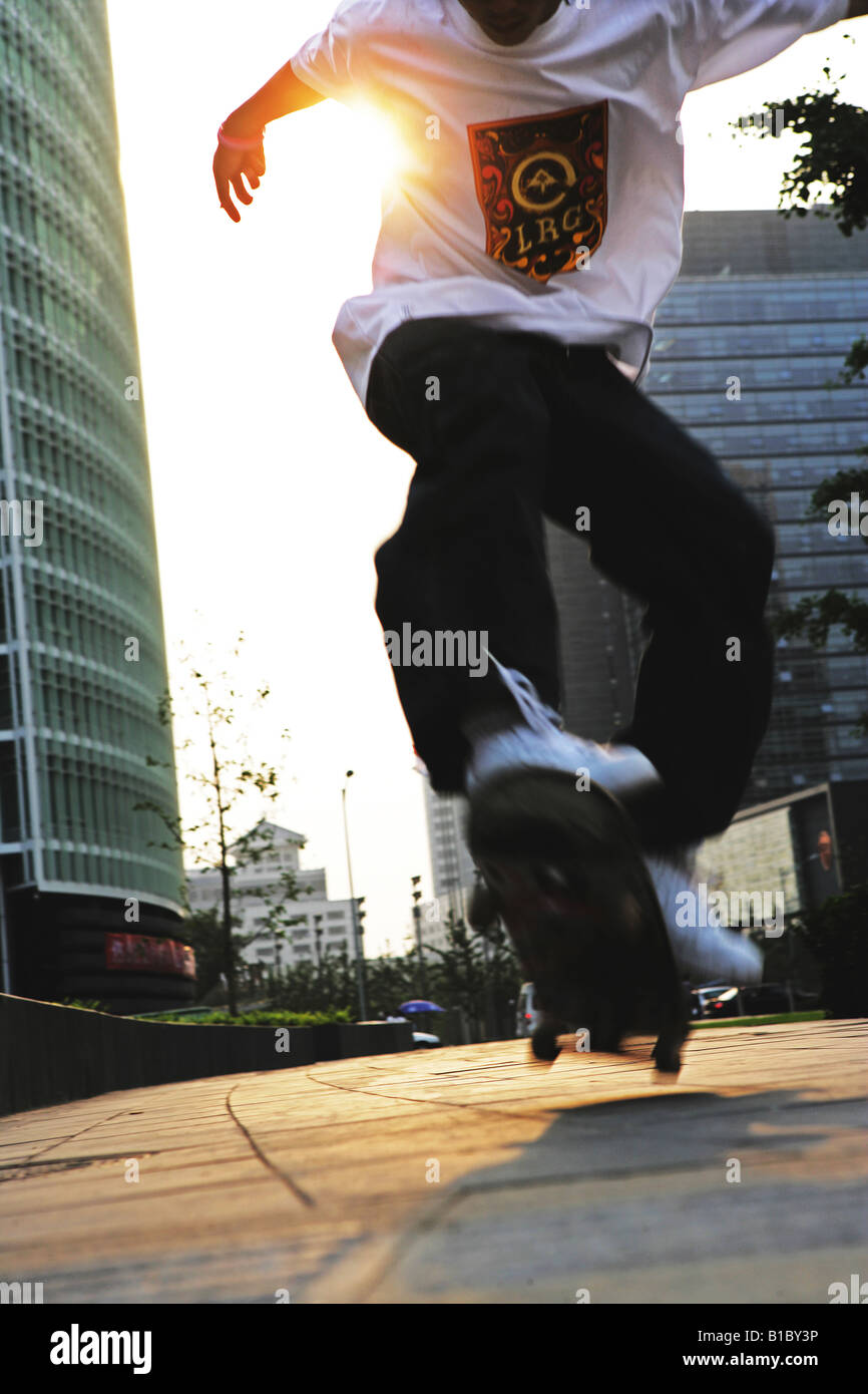 young man skateboarding on square beside office buildings,Beijing,China ...