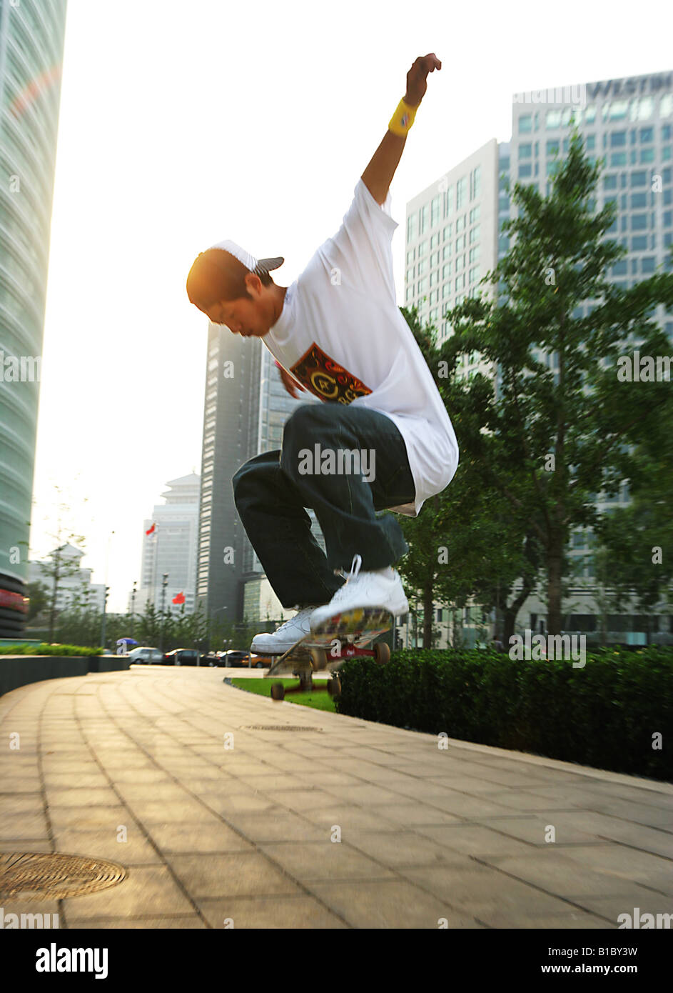 young man skateboarding on square beside office buildings,Beijing,China ...