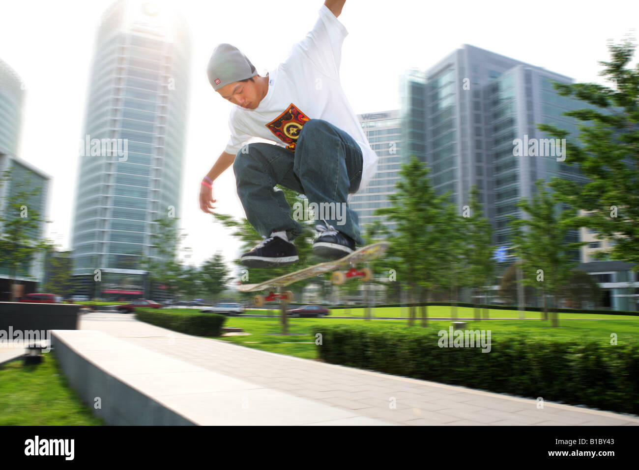 young man skateboarding on square beside office buildings,Beijing,China ...