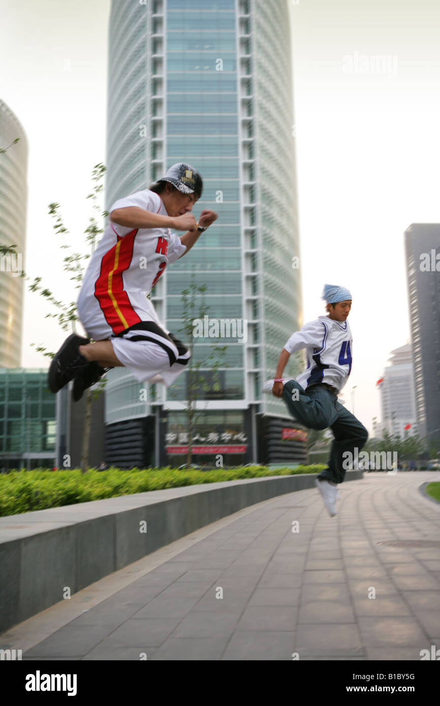 young men jumping on square beside office buildings,Beijing,China Stock ...