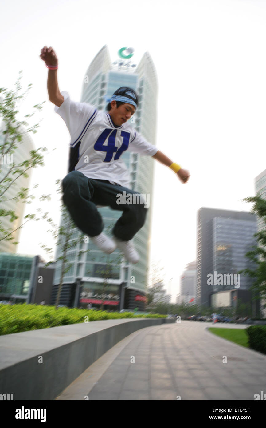 young man jumping on square beside office buildings,Beijing,China Stock ...