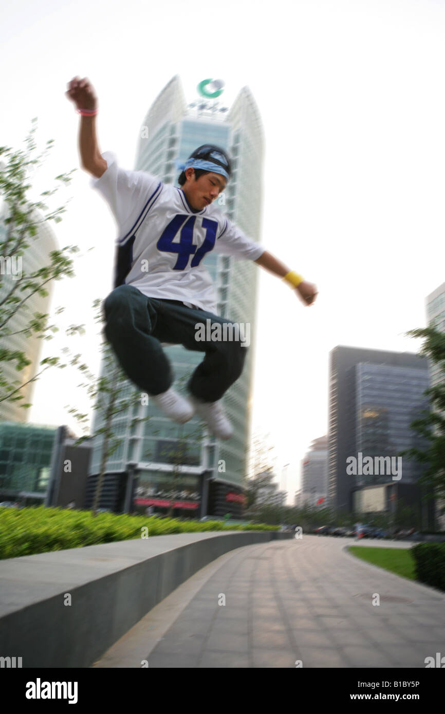 young man jumping on square beside office buildings,Beijing,China Stock ...
