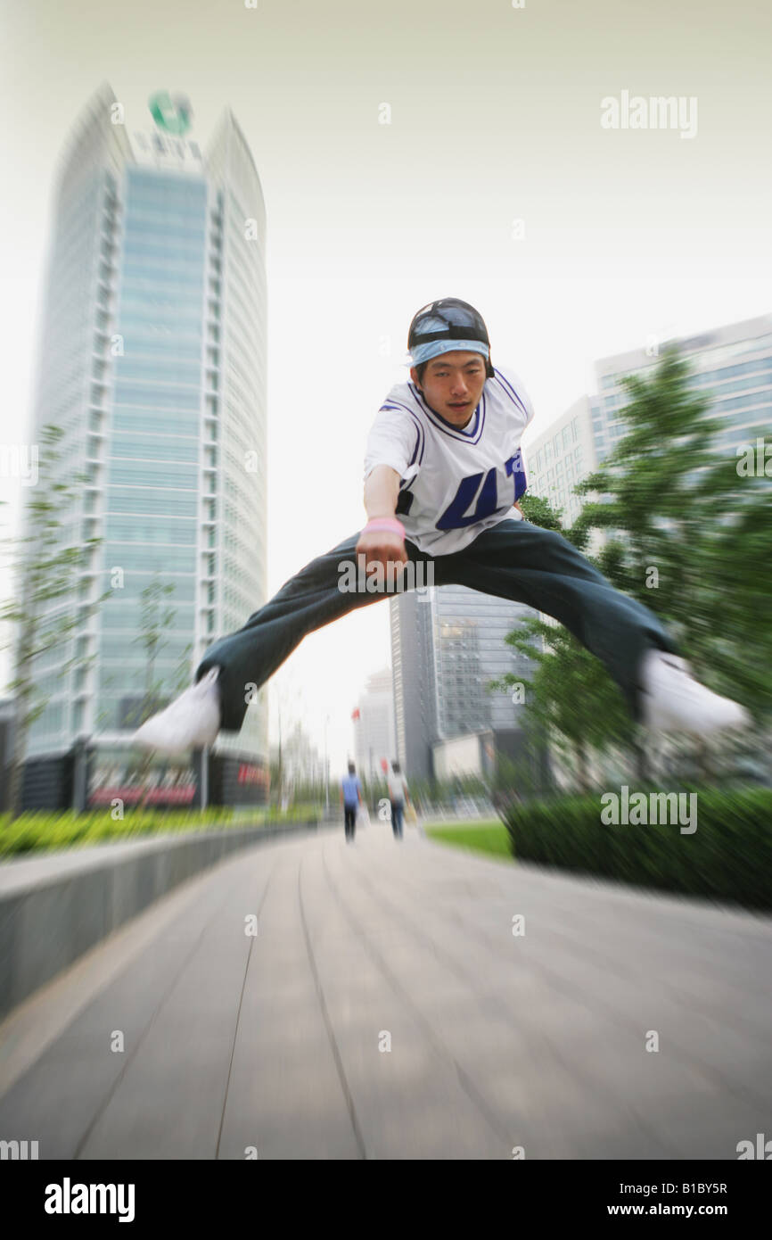 young man jumping on square beside office buildings,Beijing,China Stock ...