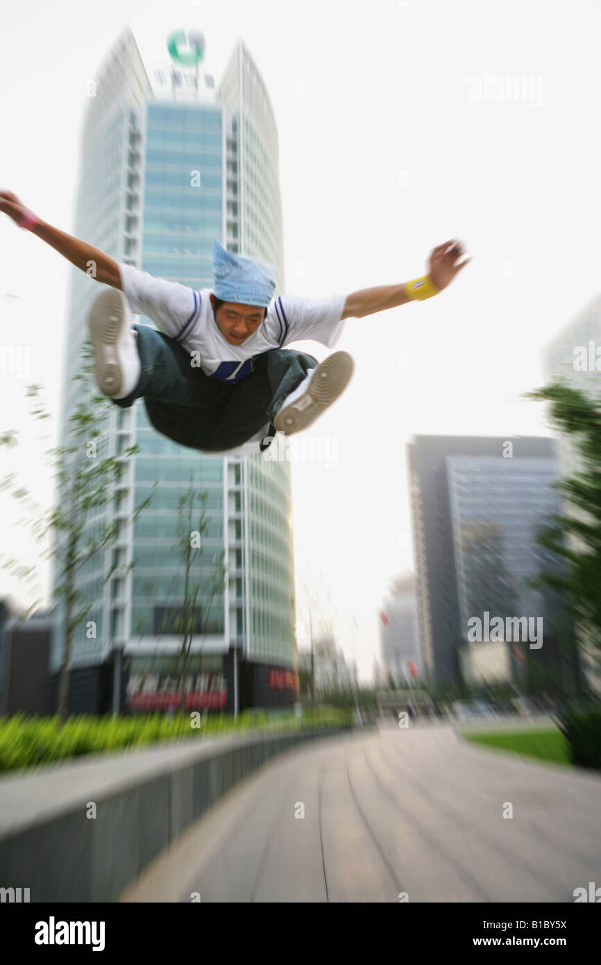 young man jumping on square beside office buildings,Beijing,China Stock ...