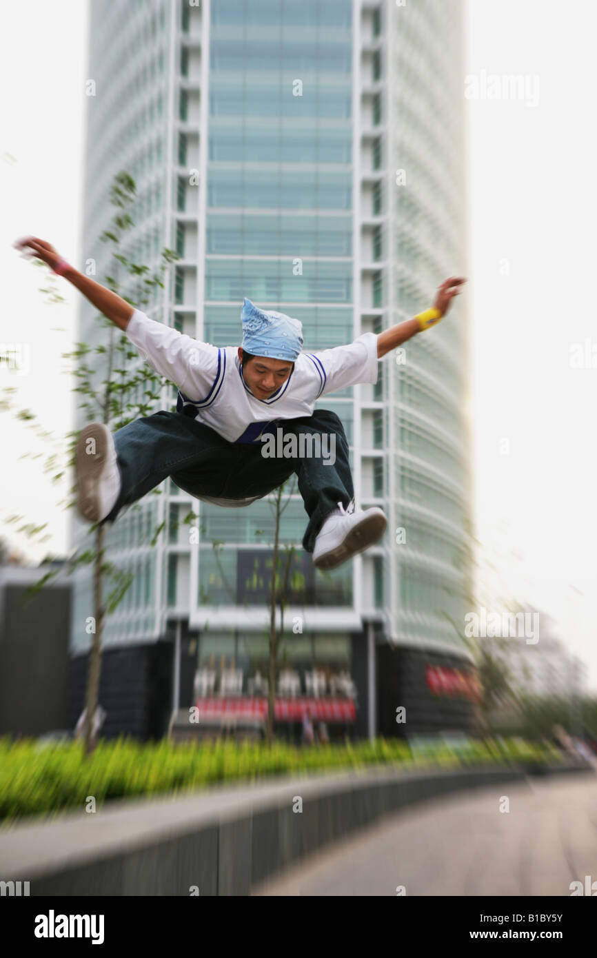 young man jumping on square beside office buildings,Beijing,China Stock ...