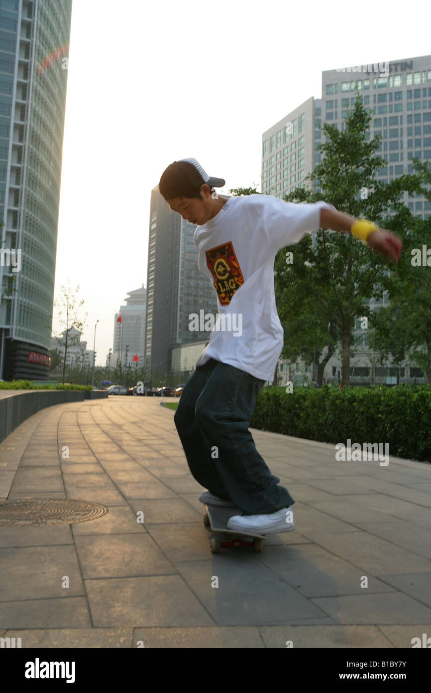 young man skateboarding on square beside office buildings,Beijing,China ...