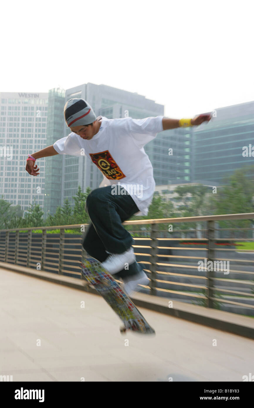 young man skateboarding on square beside office buildings,Beijing,China ...