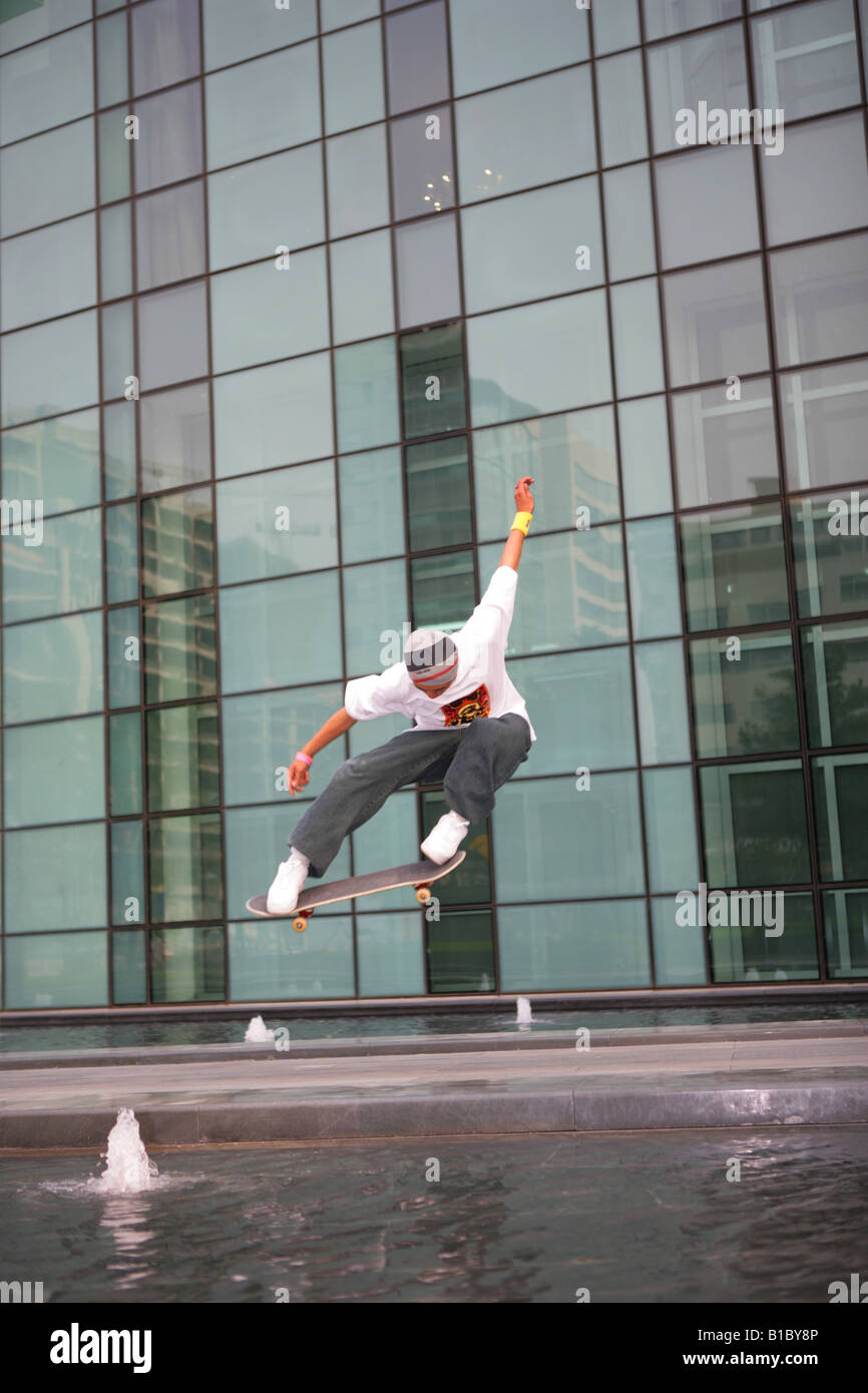 young man skateboarding on square beside office buildings,Beijing,China ...