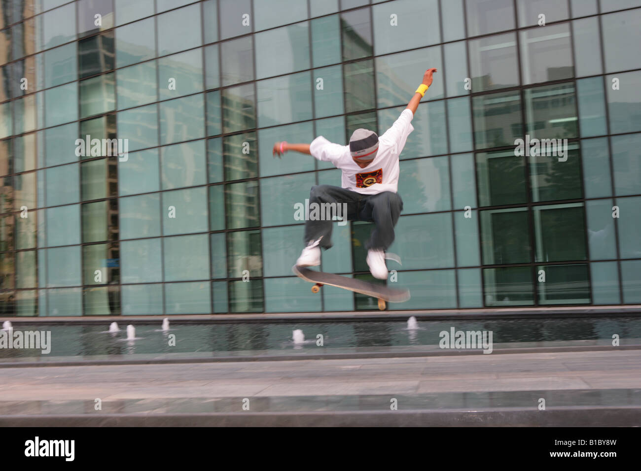 young man skateboarding on square beside office buildings,Beijing,China ...