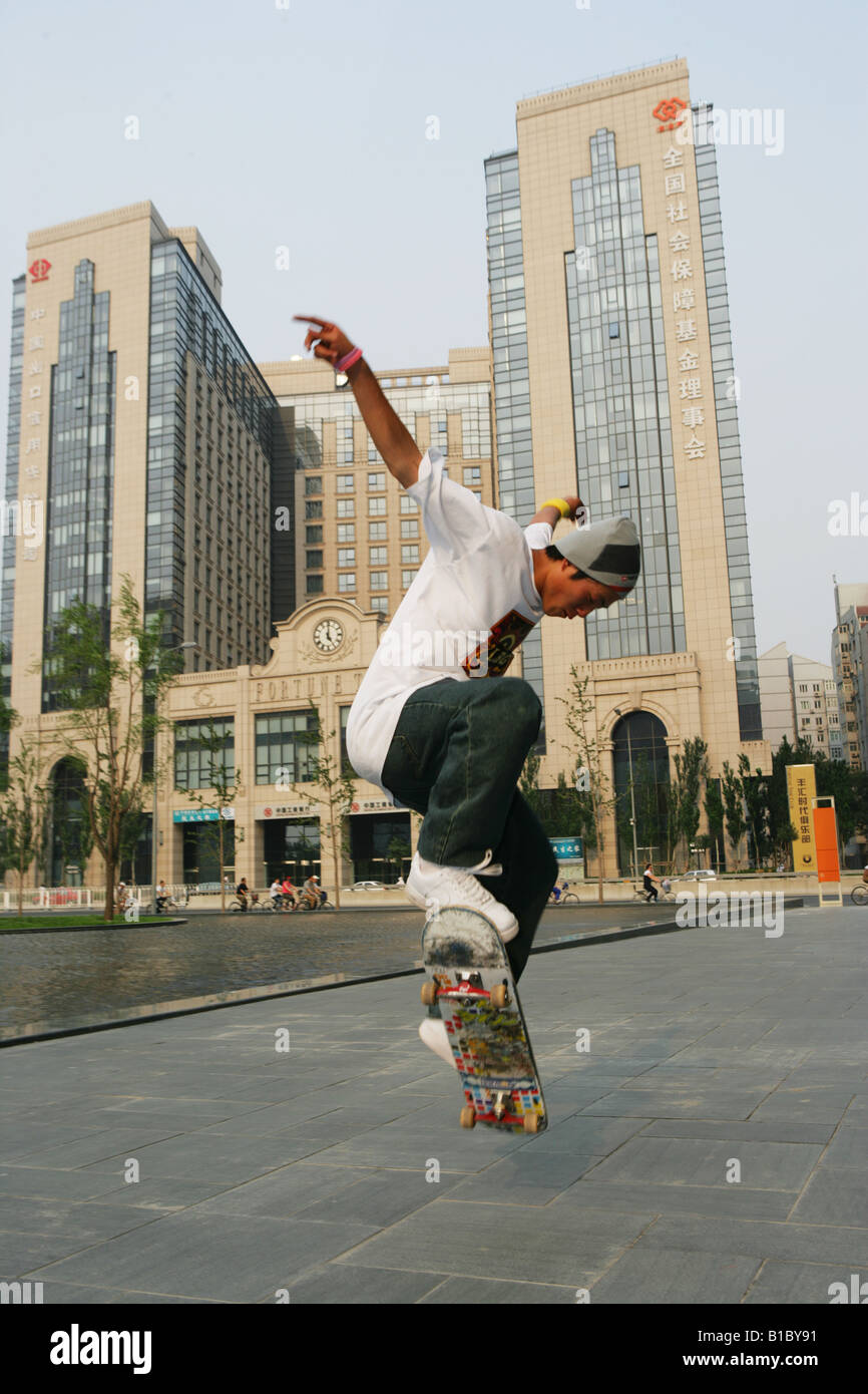 young man skateboarding on square beside office buildings,Beijing,China ...