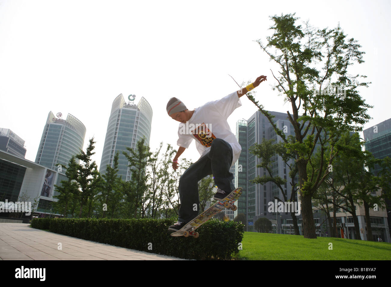young man skateboarding on square beside office buildings,Beijing,China ...
