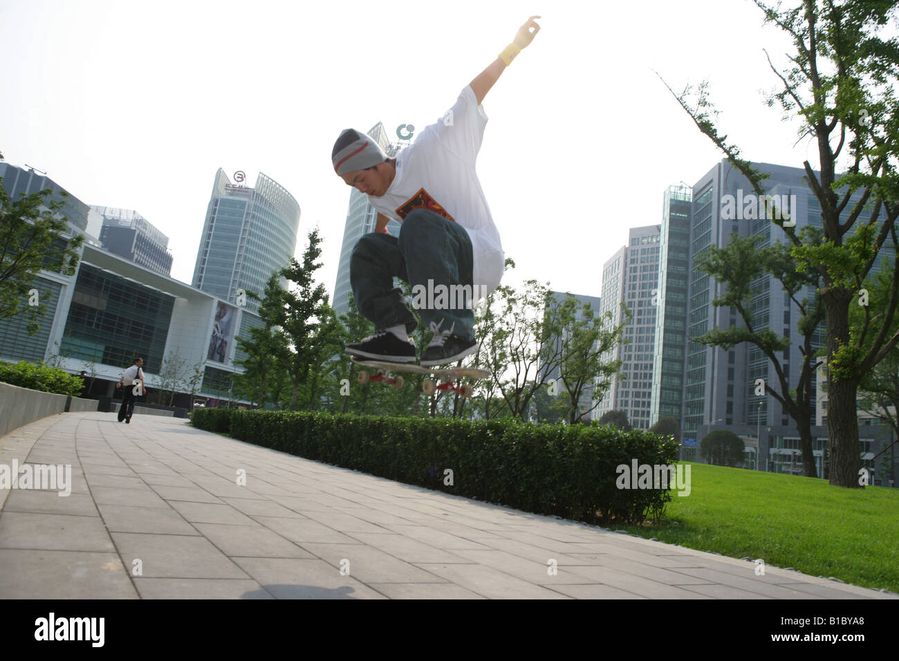 young man skateboarding on square beside office buildings,Beijing,China ...