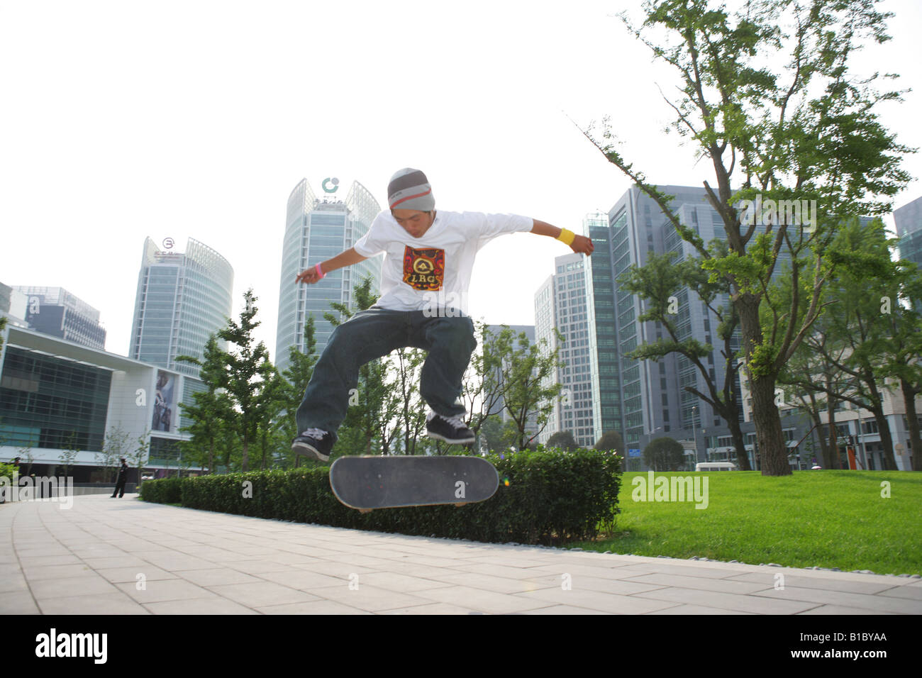young man skateboarding on square beside office buildings,Beijing,China ...