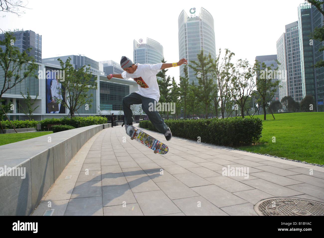young man skateboarding on square beside office buildings,Beijing,China ...