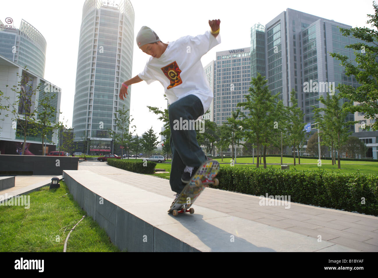 young man skateboarding on square beside office buildings,Beijing,China ...