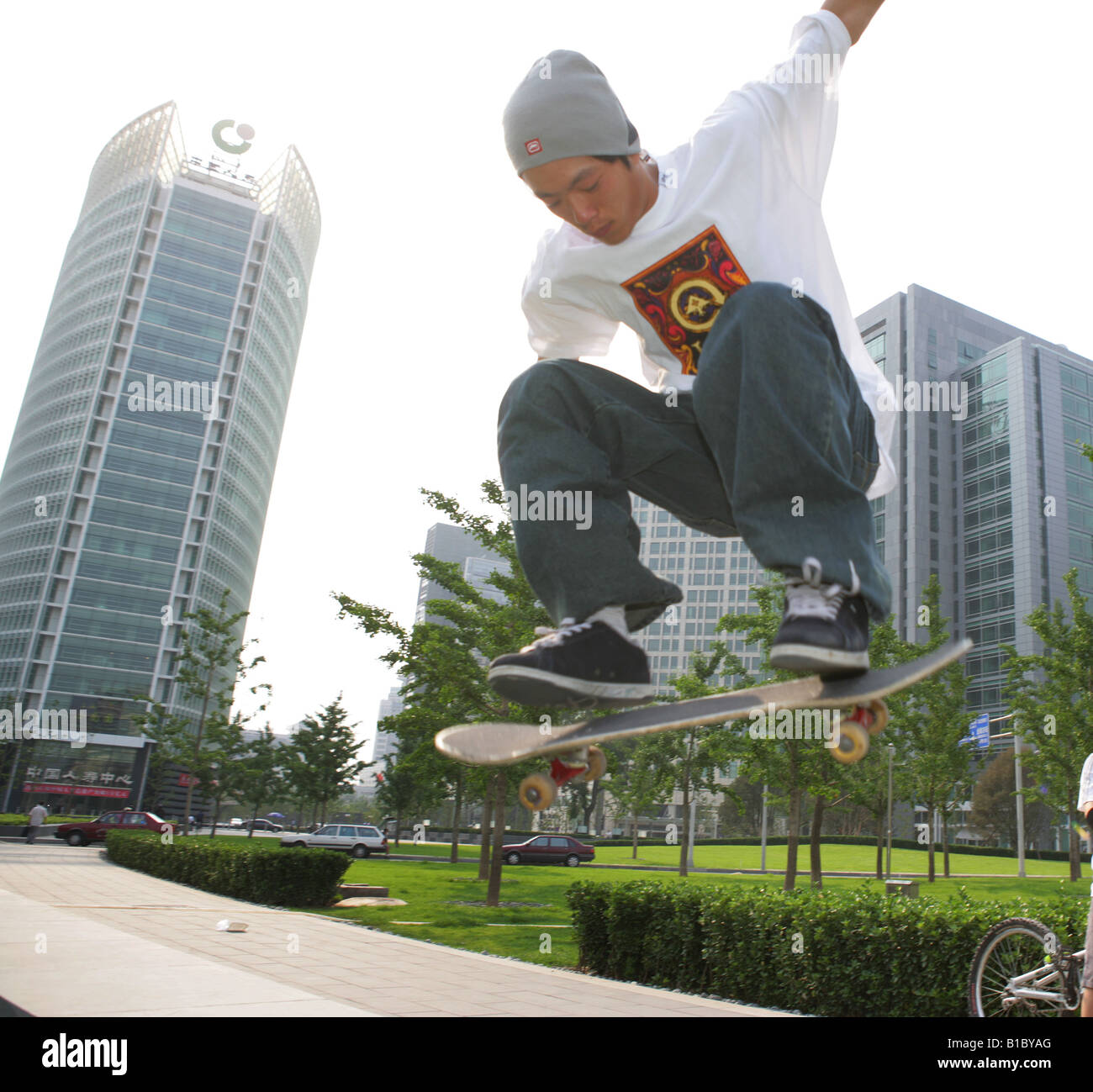young man skateboarding on square beside office buildings,Beijing,China ...