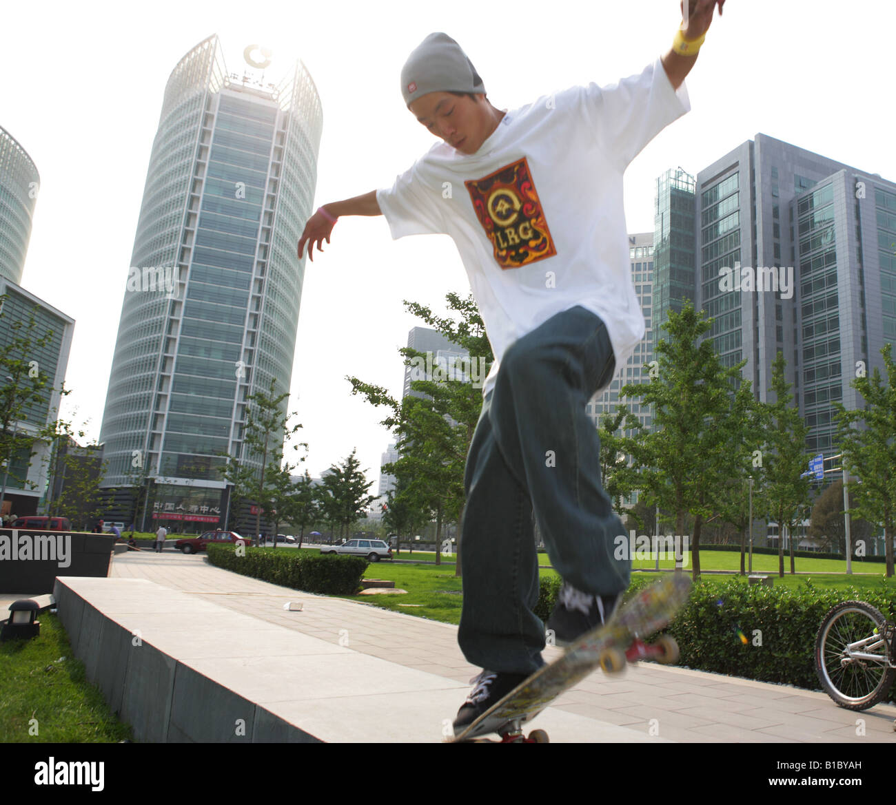 young man skateboarding on square beside office buildings,Beijing,China ...