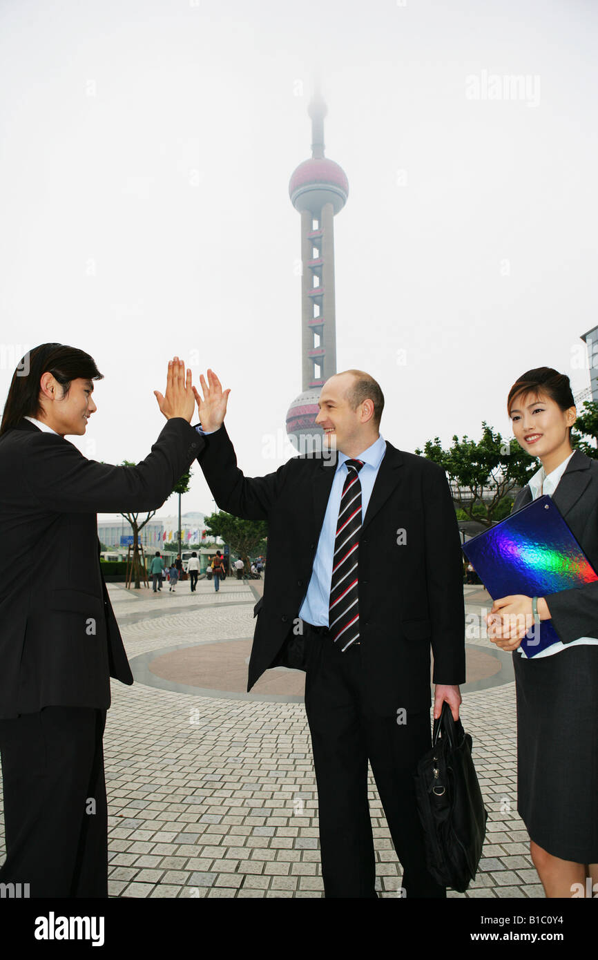 two businessmen and one businesswoman from different cultures talking ...