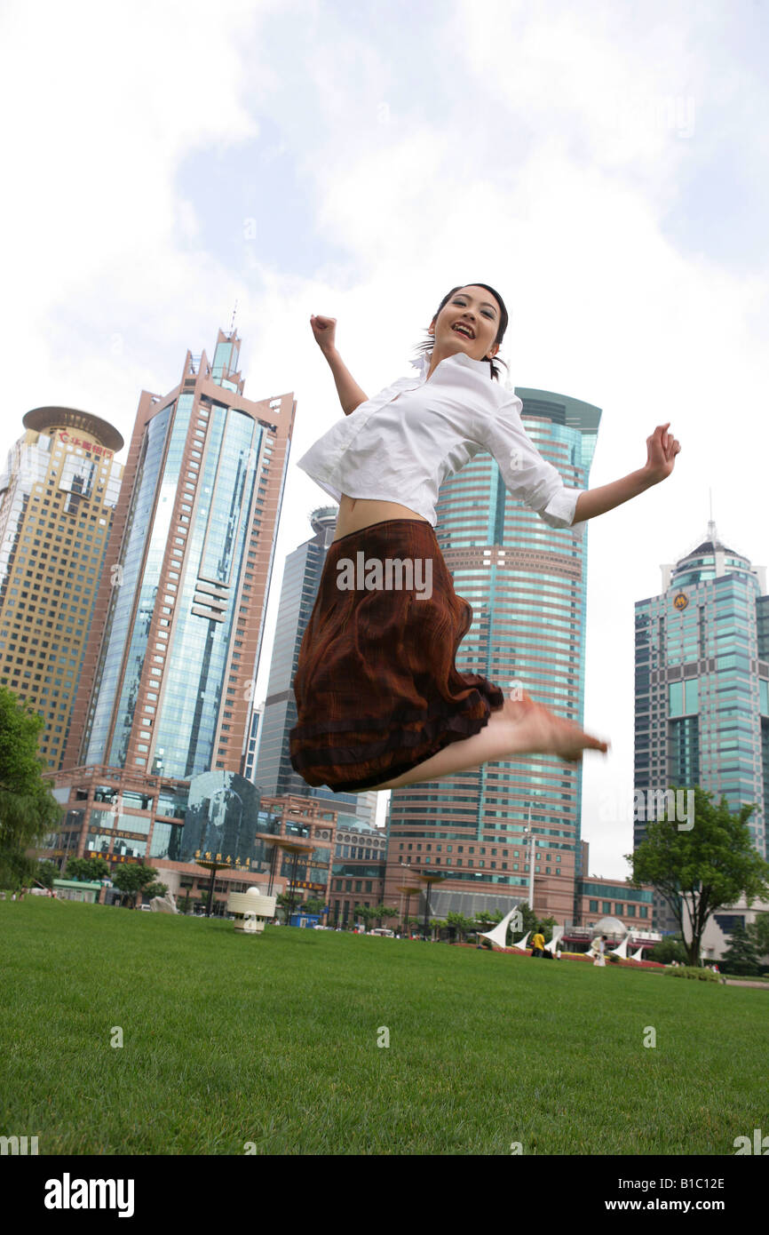 one businesswoman jumping on lawn outside office buildings in Pudong ...