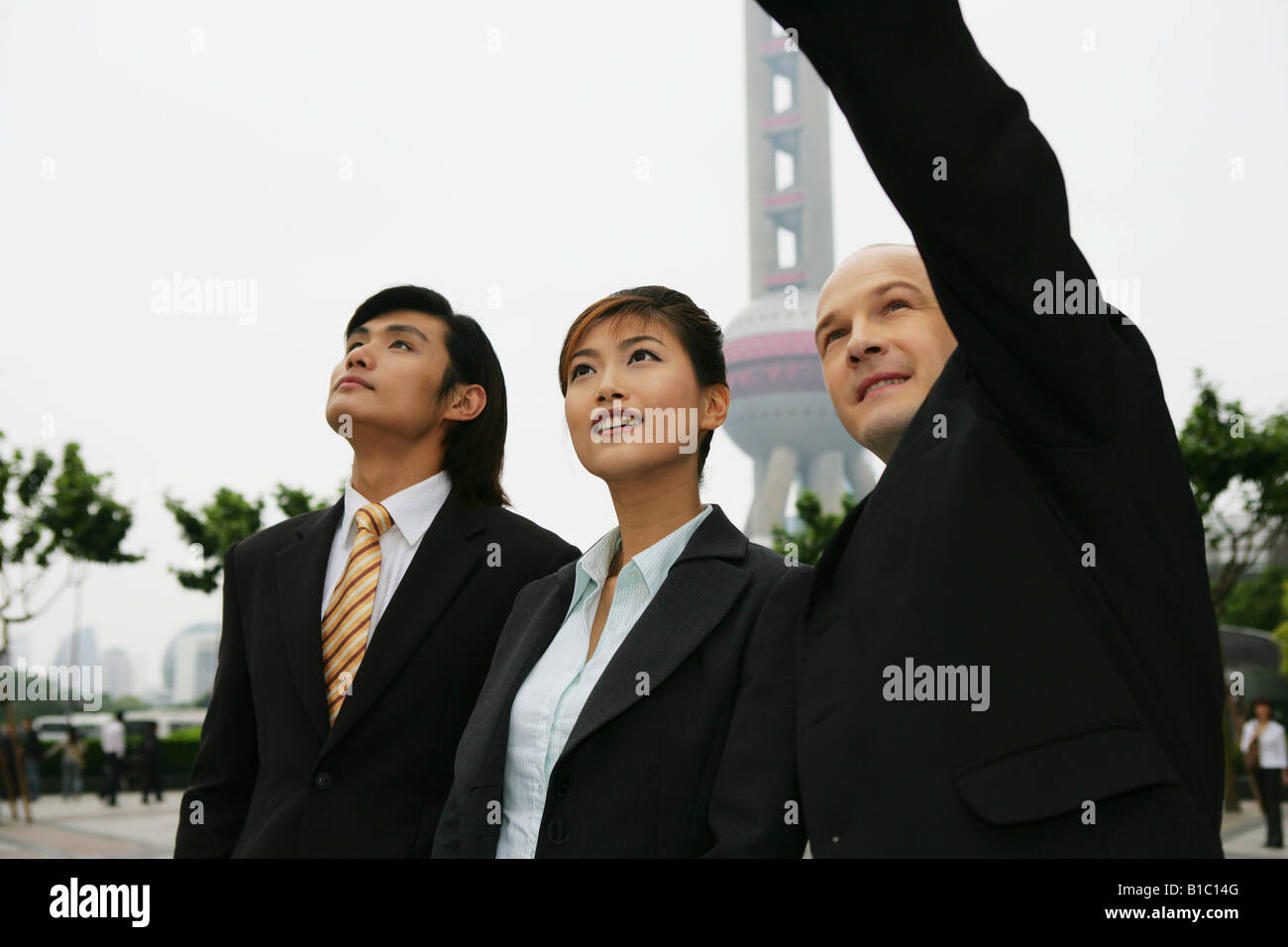 two businessmen and one businesswoman from different cultures talking ...