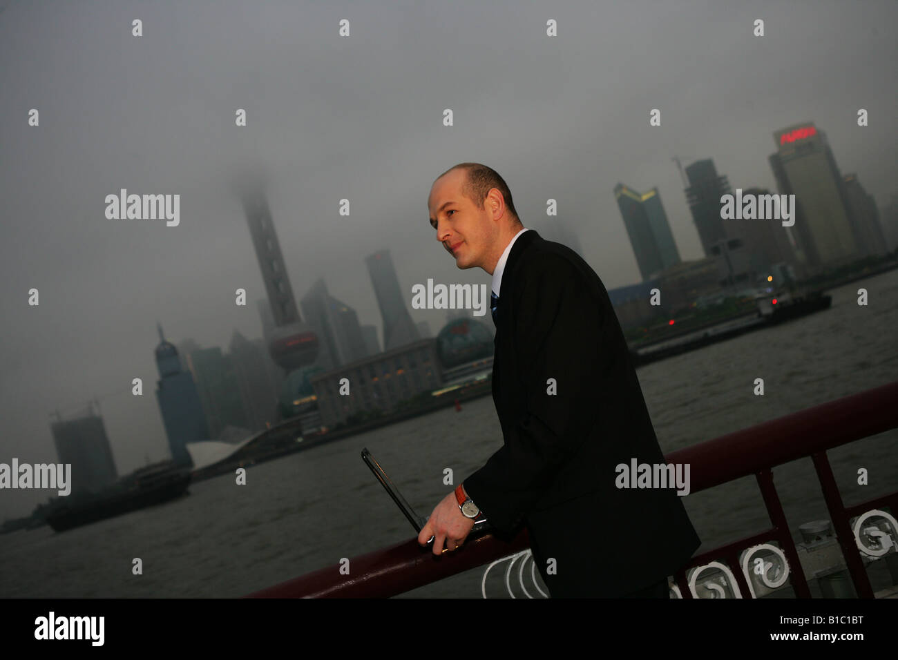 One foreign businessman using a laptop at the bund hi-res stock ...