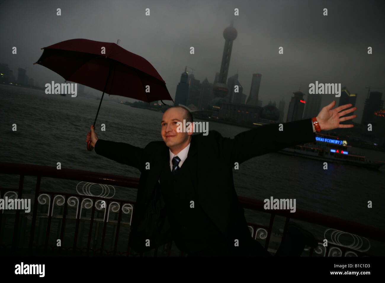 one foreign businessman arm stretched while holding an opened umbrella ...