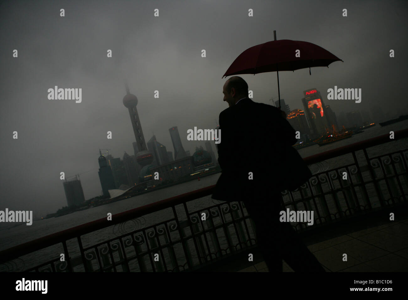 one foreign businessman smiling while holding an opened umbrella at the ...