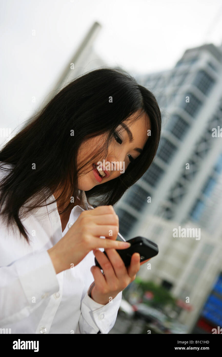 one businesswoman using a mobile phone outside office buildings in ...