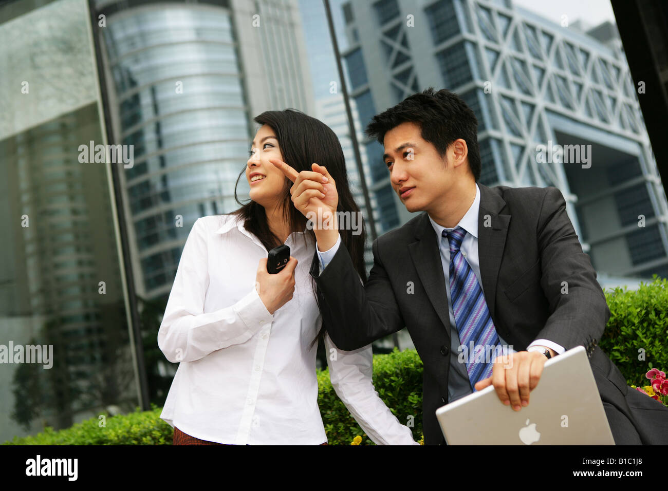 one businessman and one businesswoman talking outside office buildings ...