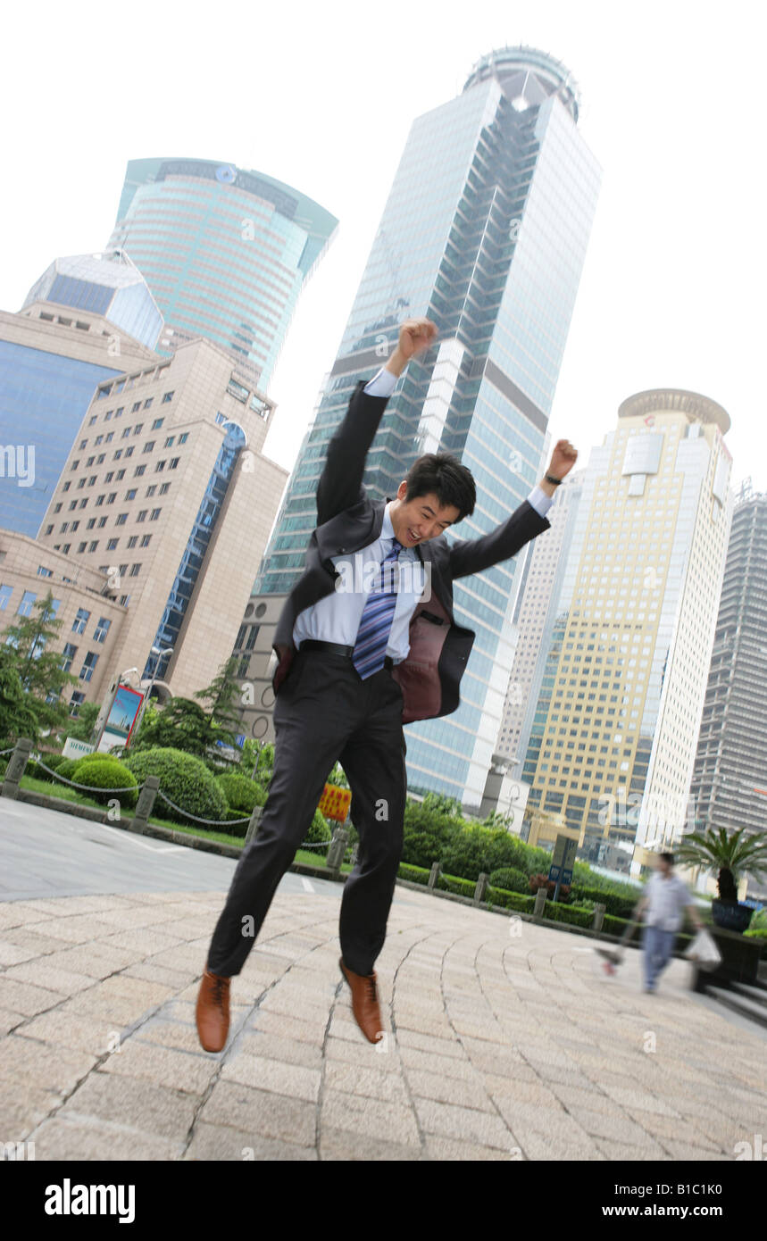 one businessman jumping with passion outside office buildings in Pudong ...