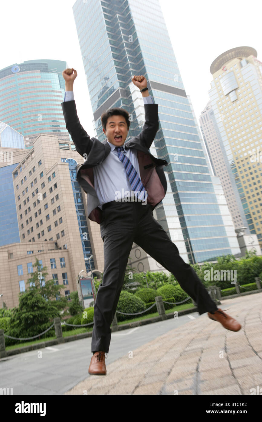 one businessman jumping with passion outside office buildings in Pudong ...
