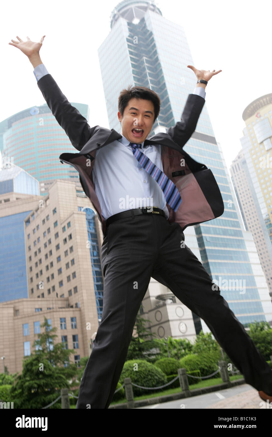 one businessman jumping with passion outside office buildings in Pudong ...
